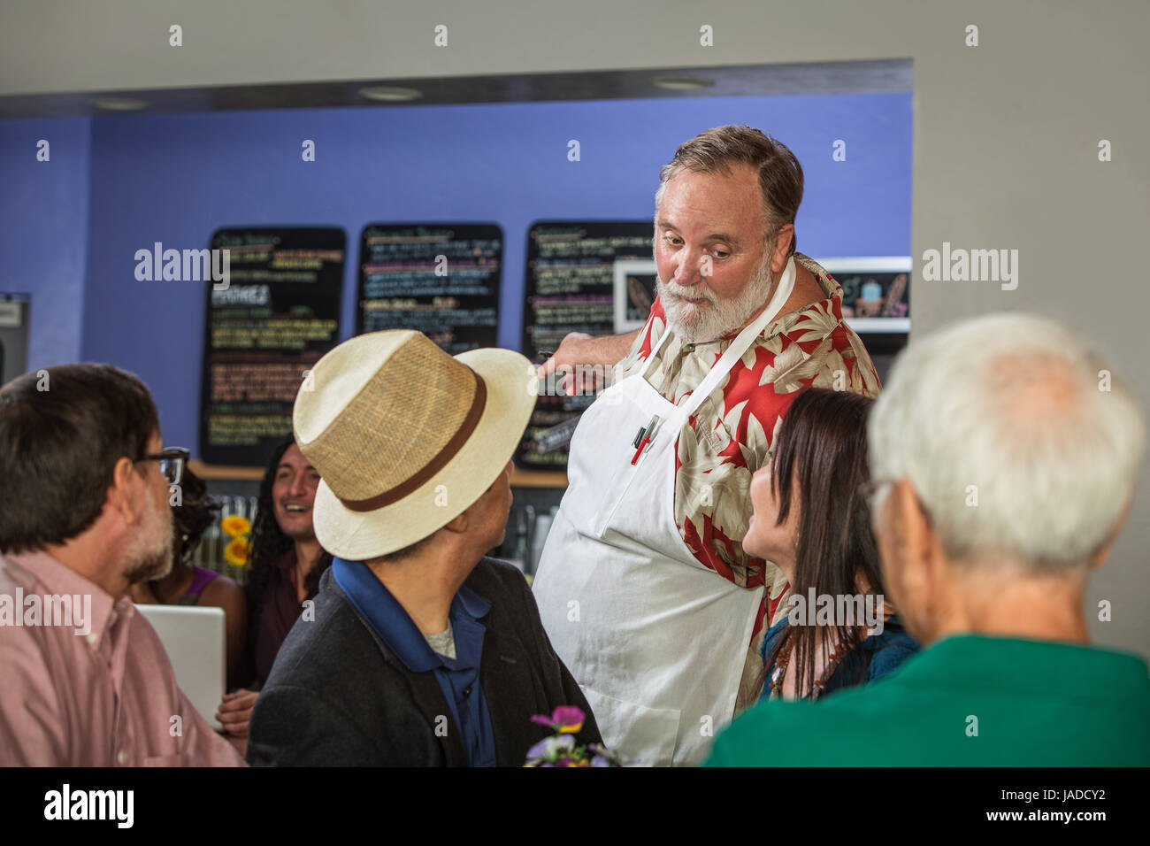 Handsome cafe barista showing customers menu Stock Photo - Alamy