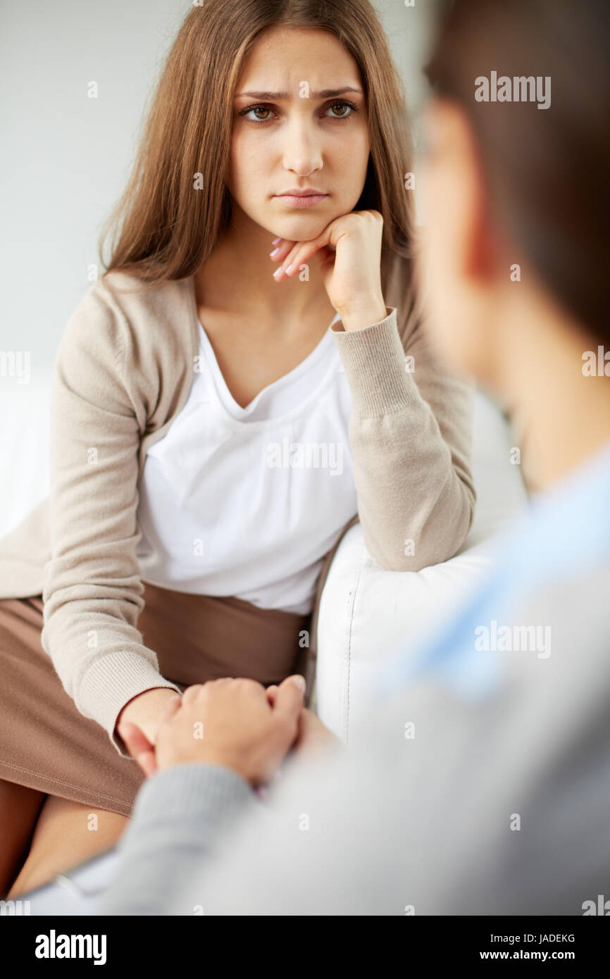 Image of sad patient looking at psychiatrist during discussion of her ...
