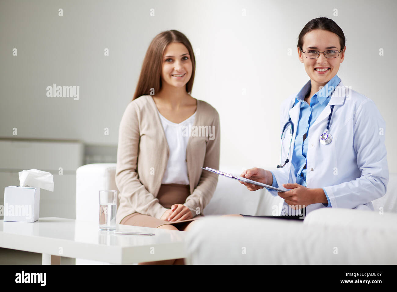 Female psychiatrist looking at camera on background of her patient ...