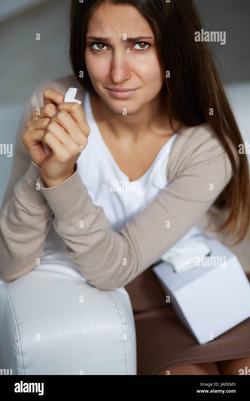 Sad girl with paper tissue looking at camera Stock Photo - Alamy