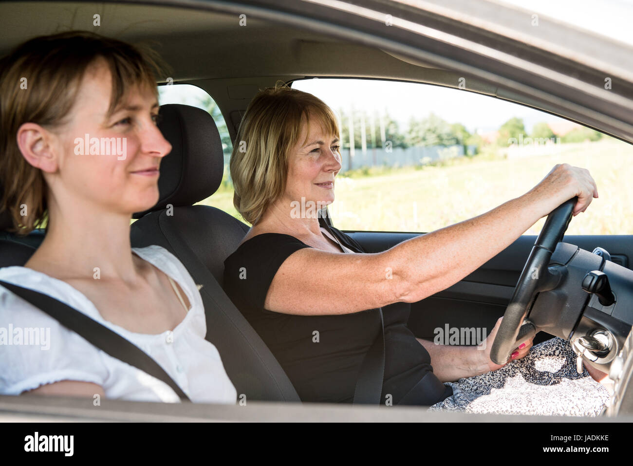 Smiling mature woman driving car with her adult child Stock Photo - Alamy
