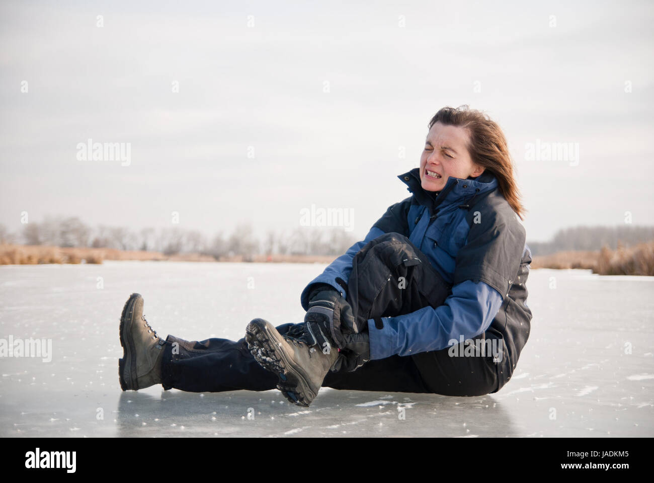 Young woman with ankle injury on frozen icy lake Stock Photo - Alamy