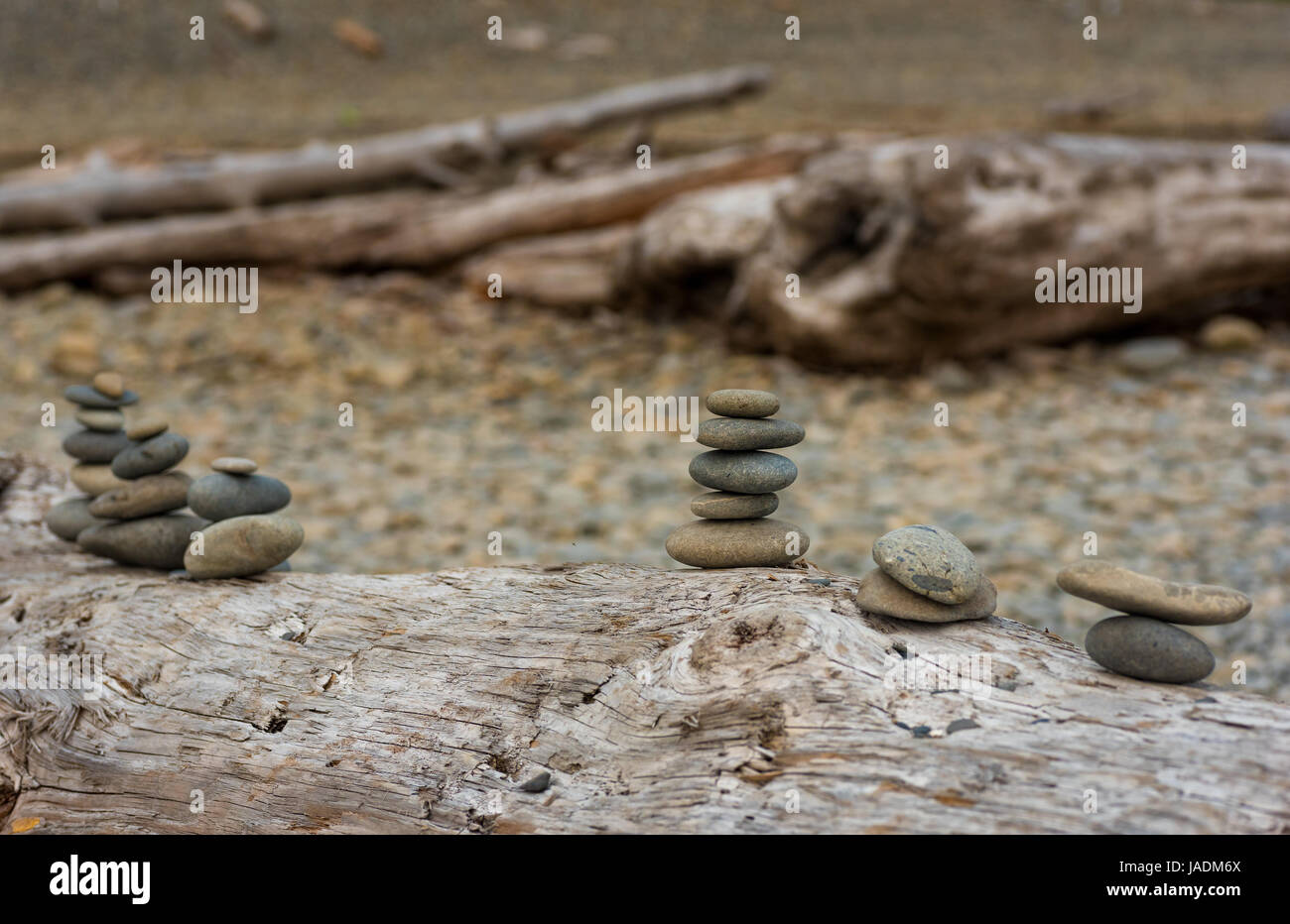Small piles of stacked stones on a driftwood log at Ruby Beach on ...