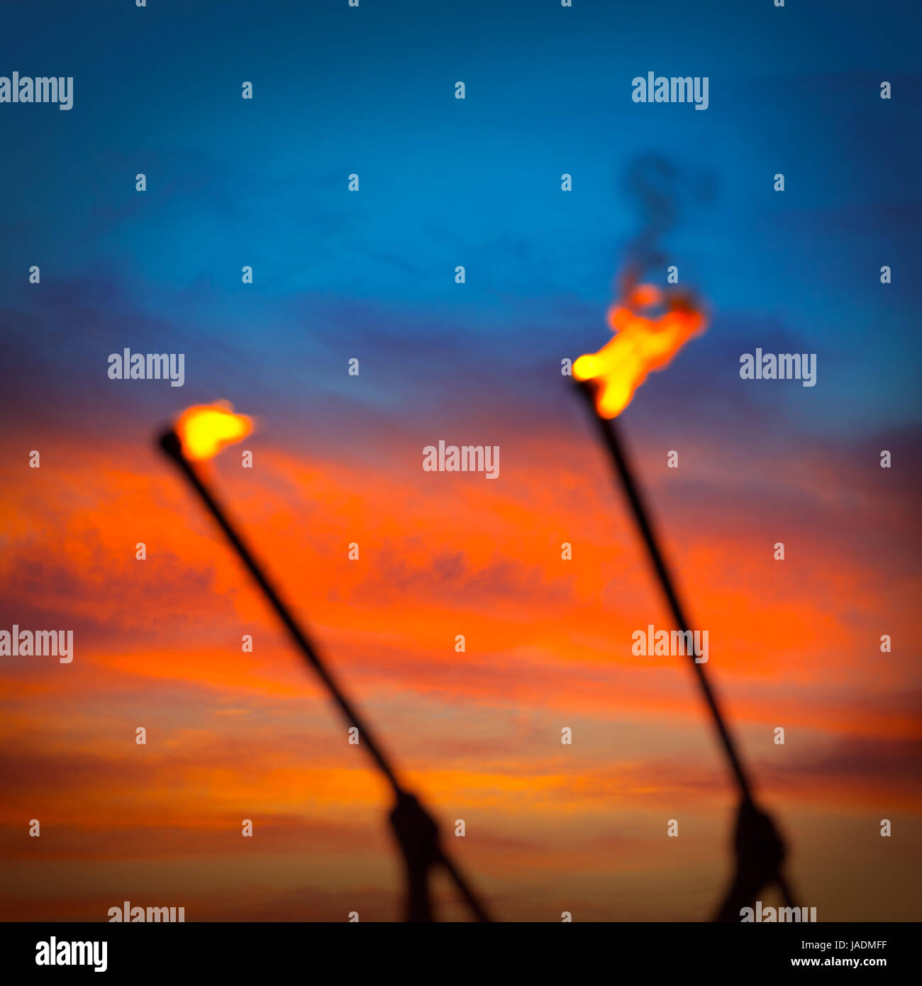 Fire torch at sunset sky with red clouds background Stock Photo - Alamy