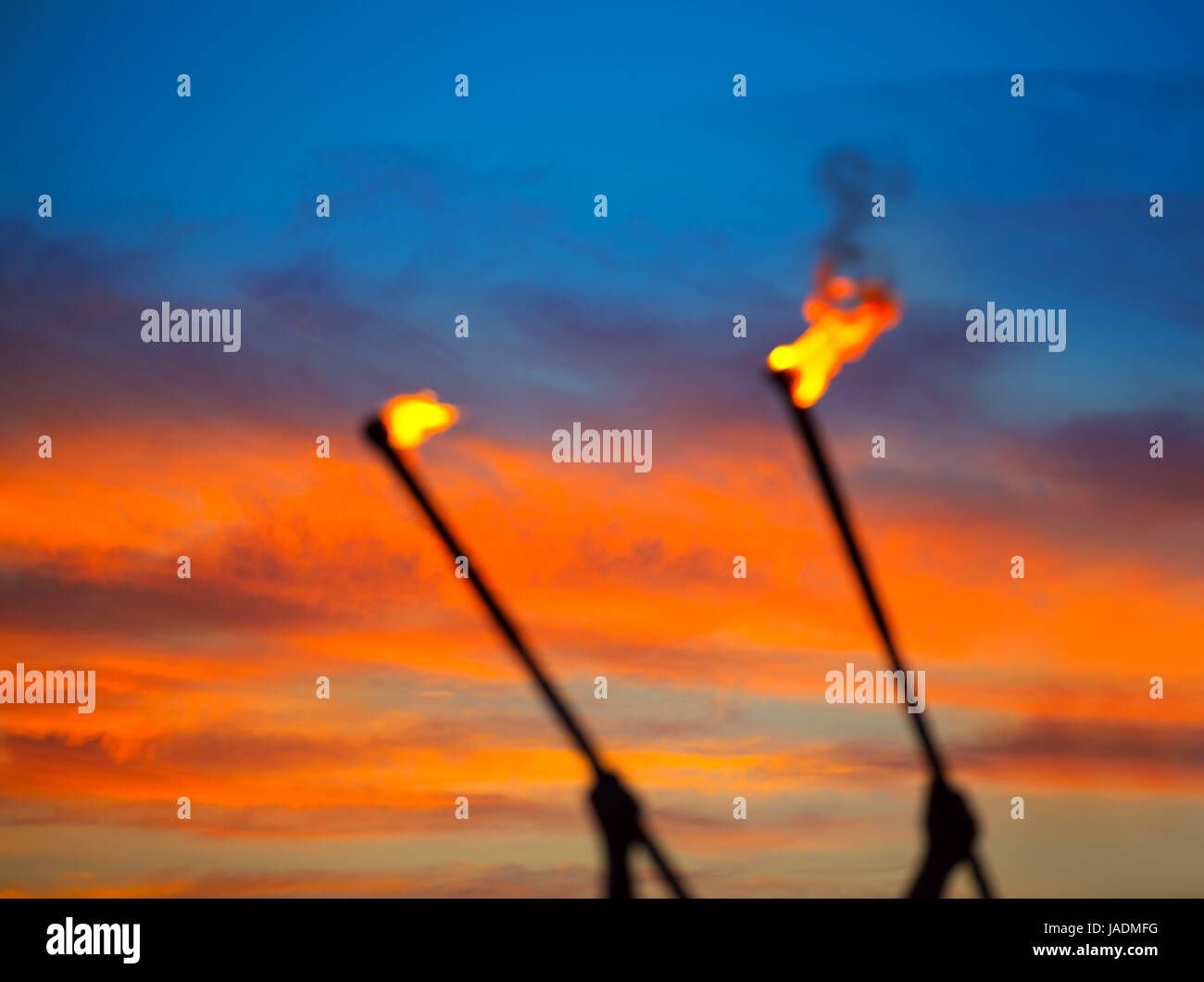 Fire torch at sunset sky with red clouds background Stock Photo - Alamy