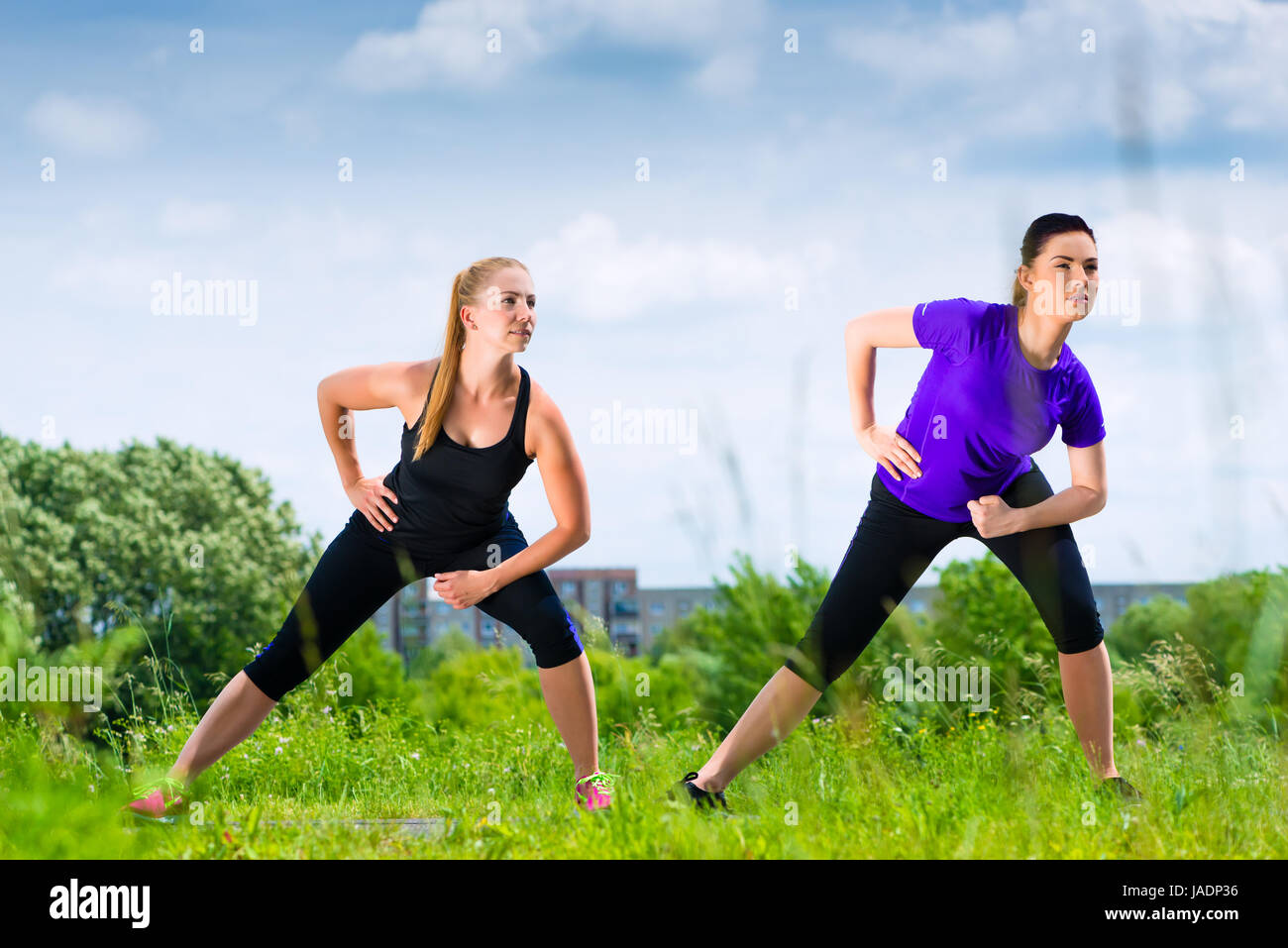 Urban sports - young women doing warming up together before running in ...