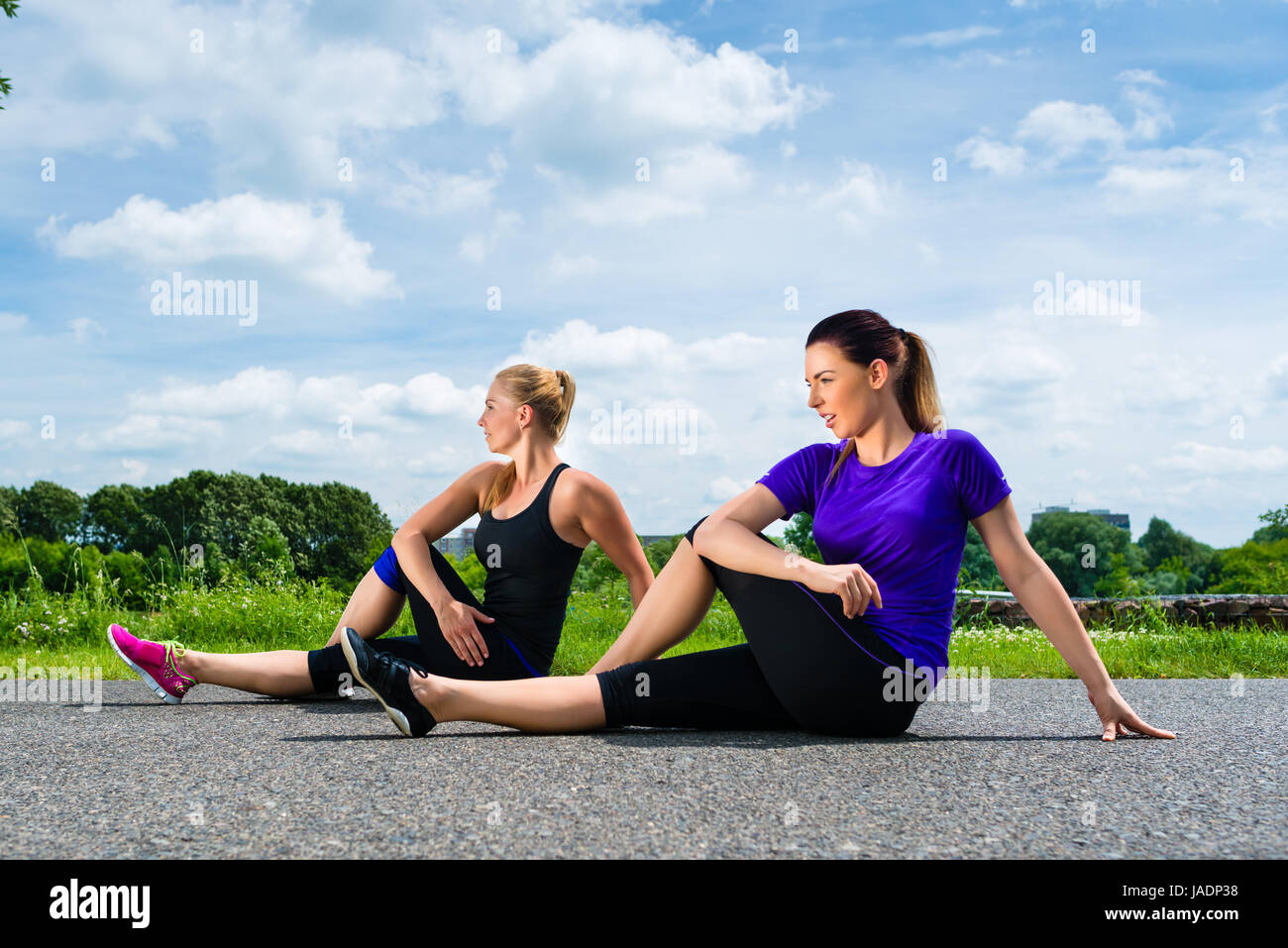 Urban sports - young women doing warming up together before running in ...
