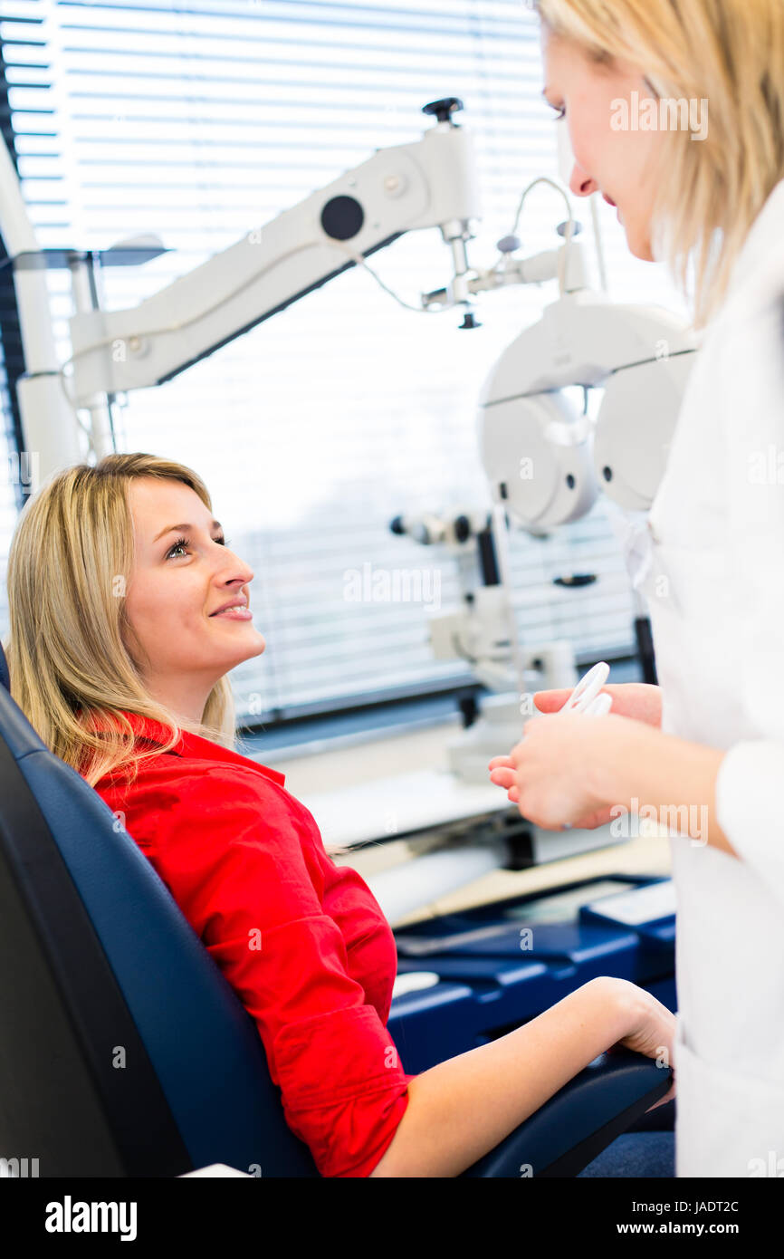 Optometry concept - pretty young woman having her eyes examined by an ...