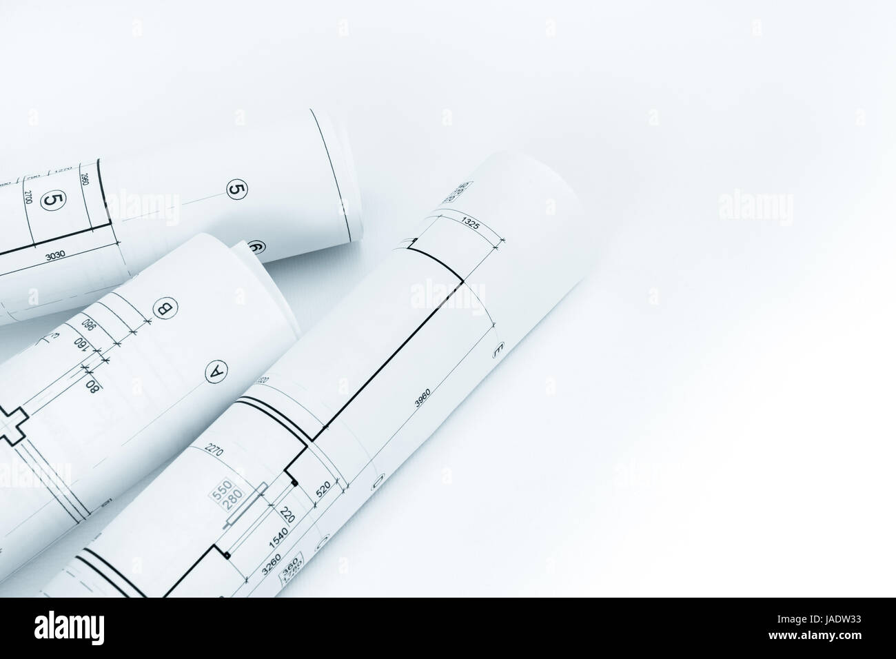 architect workspace with rolls of blueprints and technical drawings ...