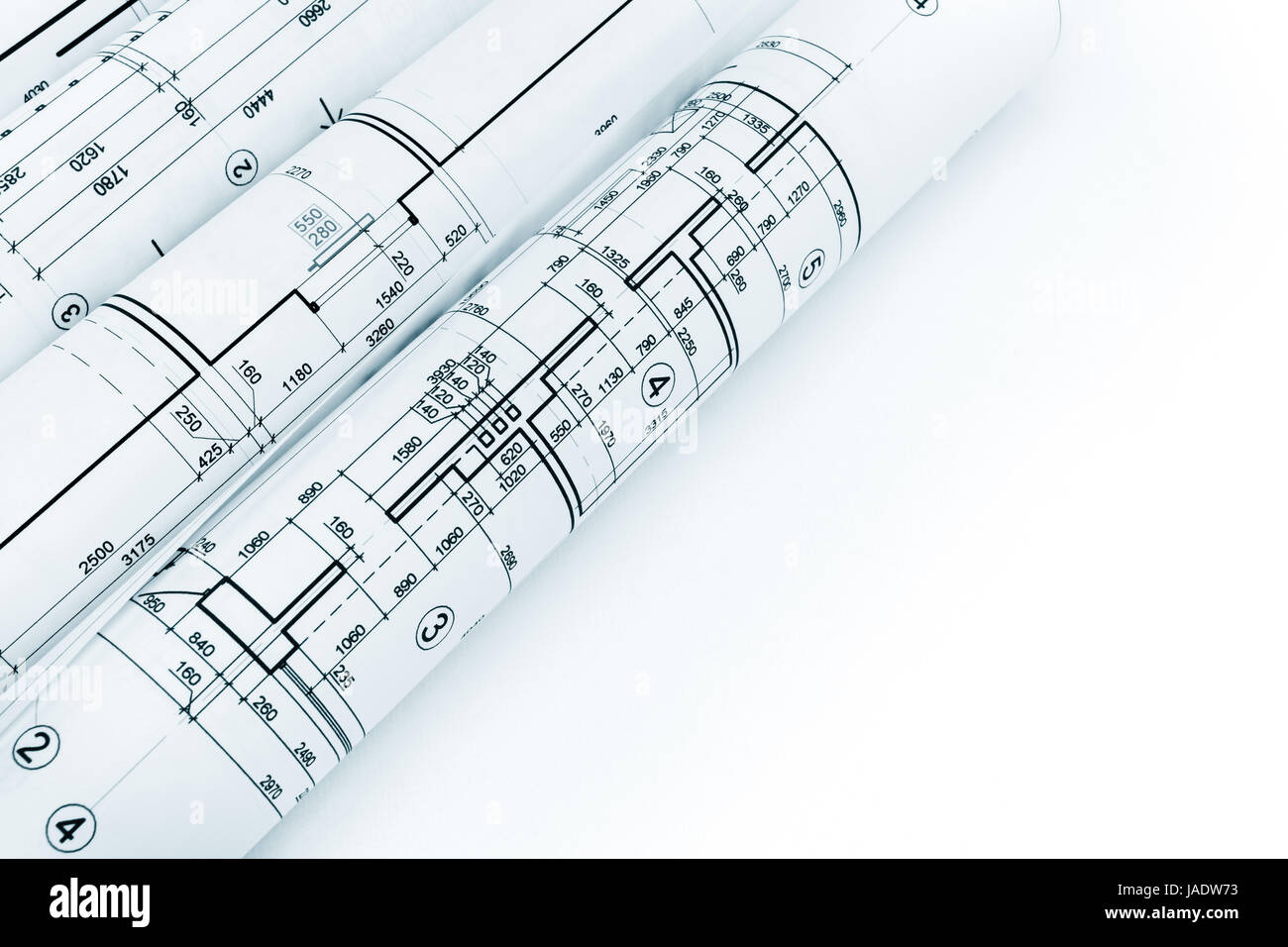 rolls of architectural blueprints and technical drawings on white ...