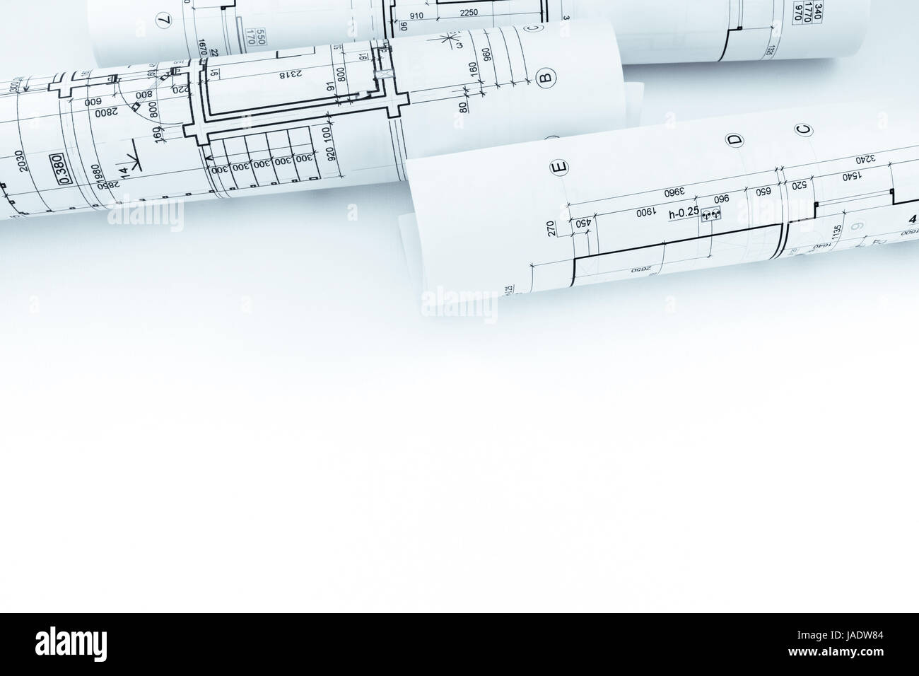 rolls of paper with graphical plans and architectural projects on white ...