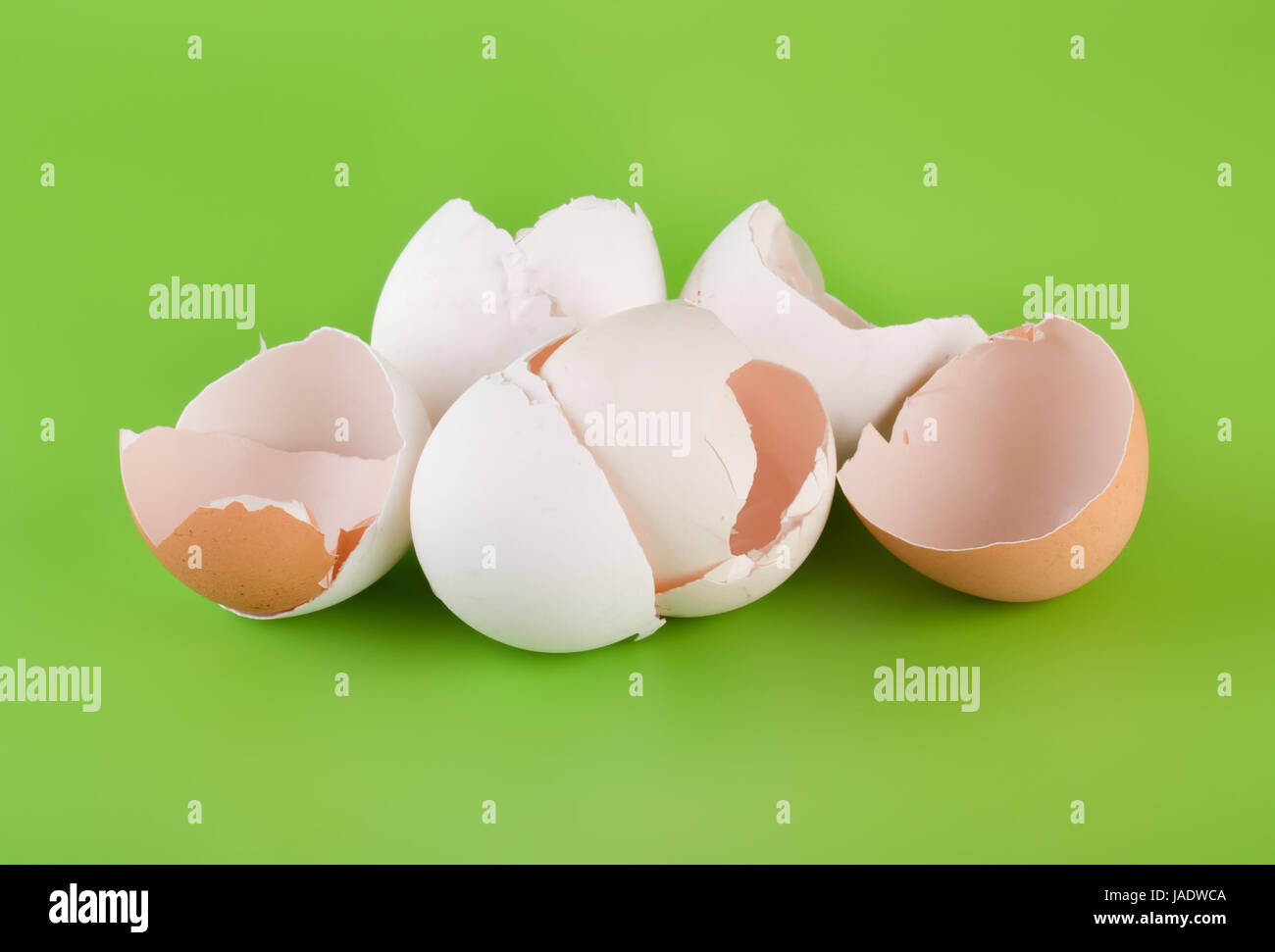 Group pieces of egg shell on a green background Stock Photo - Alamy