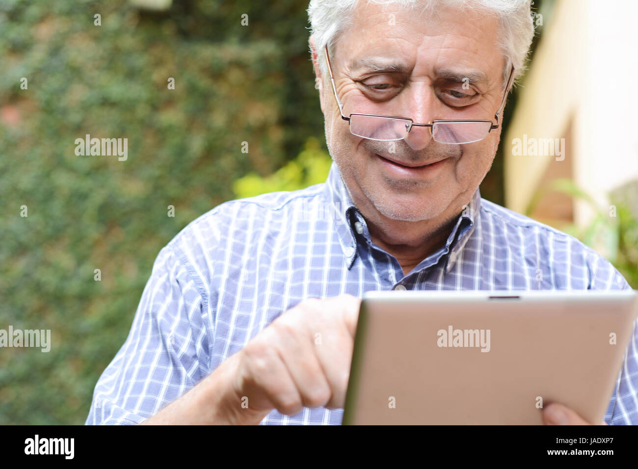 Portrait of an old man using digital tablet. Outdoors Stock Photo - Alamy