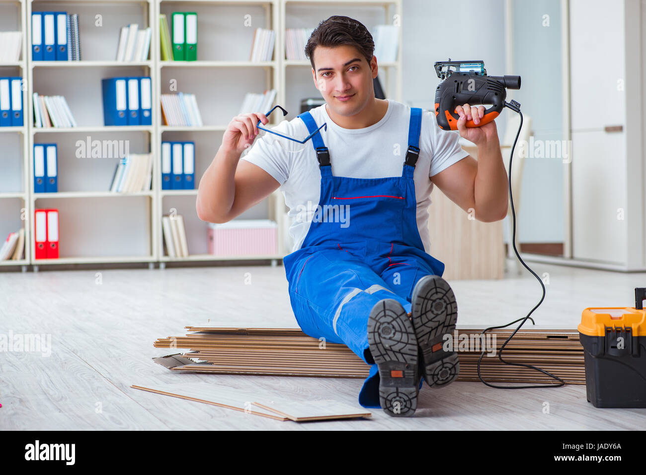 Young worker working on floor laminate tiles Stock Photo - Alamy