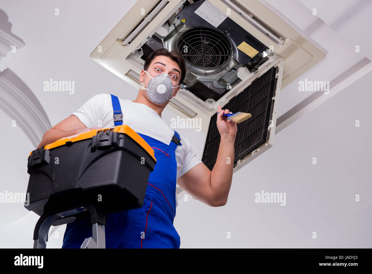 Worker repairing ceiling air conditioning unit Stock Photo - Alamy