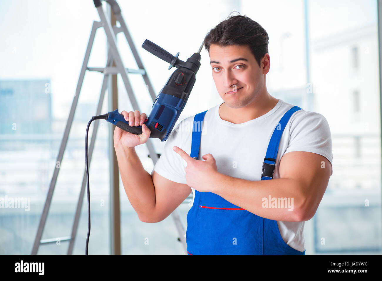 Young worker with hand drill Stock Photo - Alamy