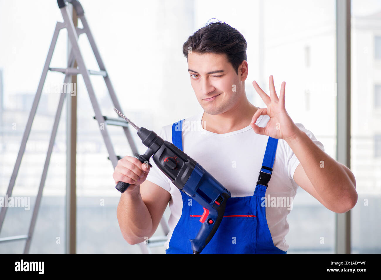 Young worker with hand drill Stock Photo - Alamy