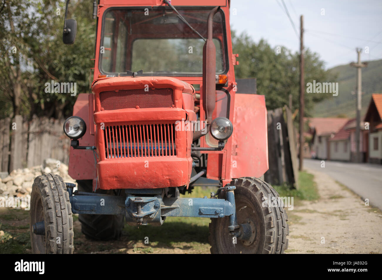 Old red funny traktor in the village Stock Photo - Alamy