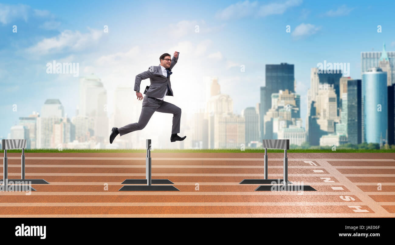 Businessman jumping over barriers in business concept Stock Photo - Alamy