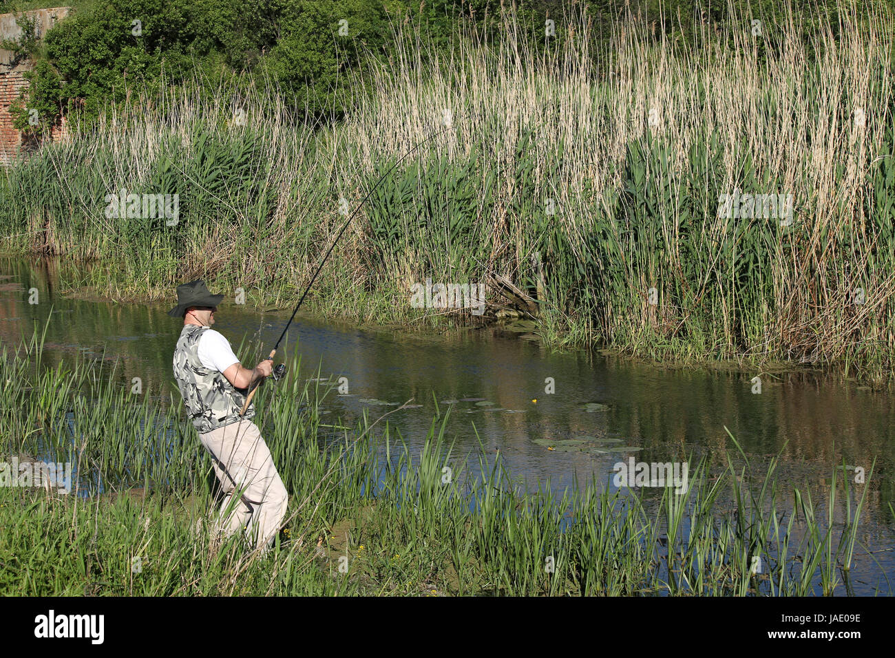 fisherman fishing fish on river Stock Photo - Alamy