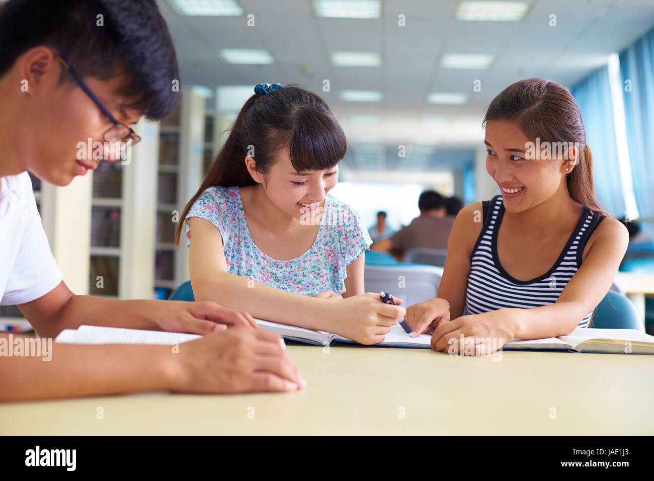 Young asian or Chinese college students study together in the library ...