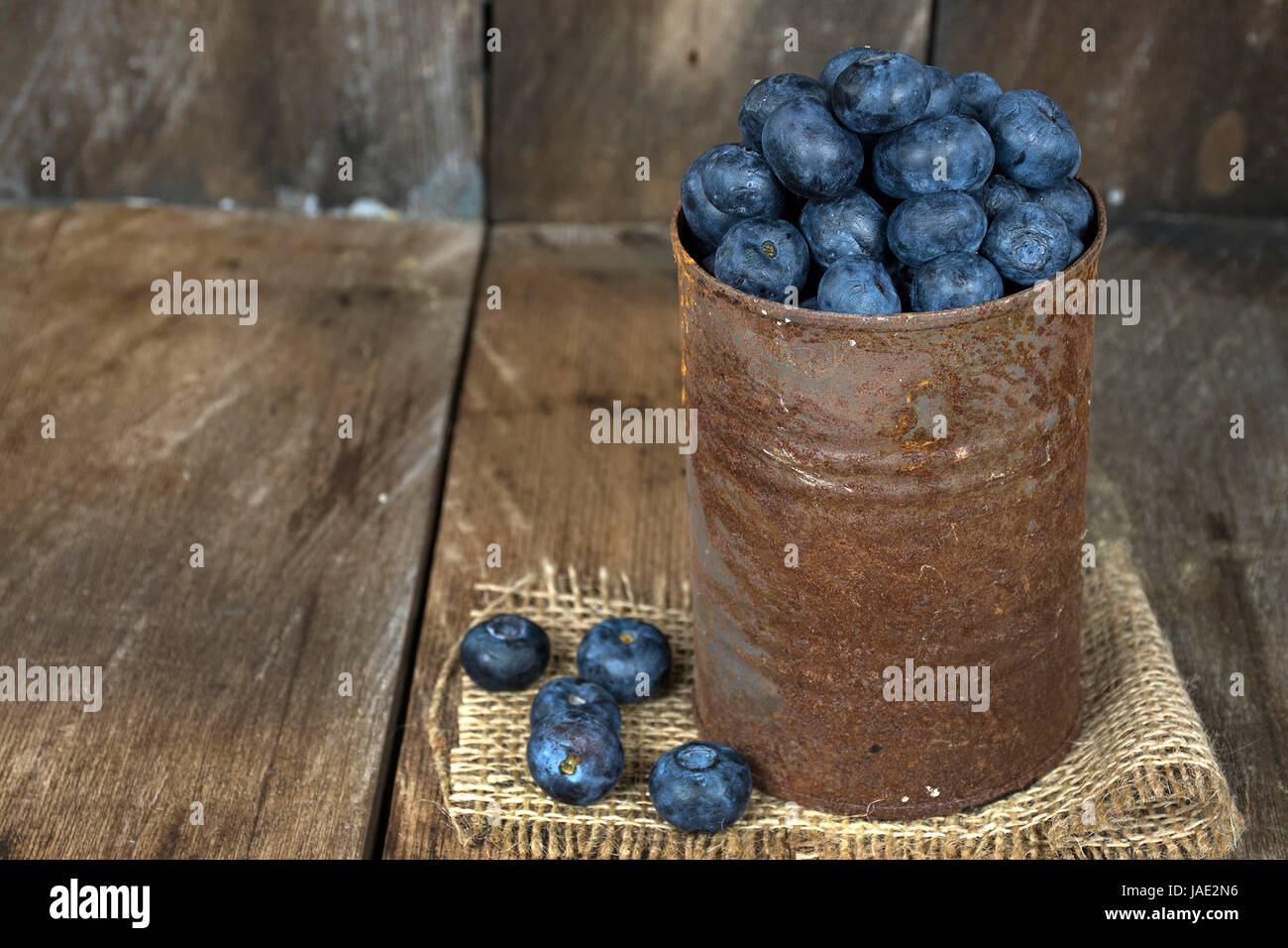 blueberries in rusty tin can on burlap and rustic barn wood Stock Photo ...