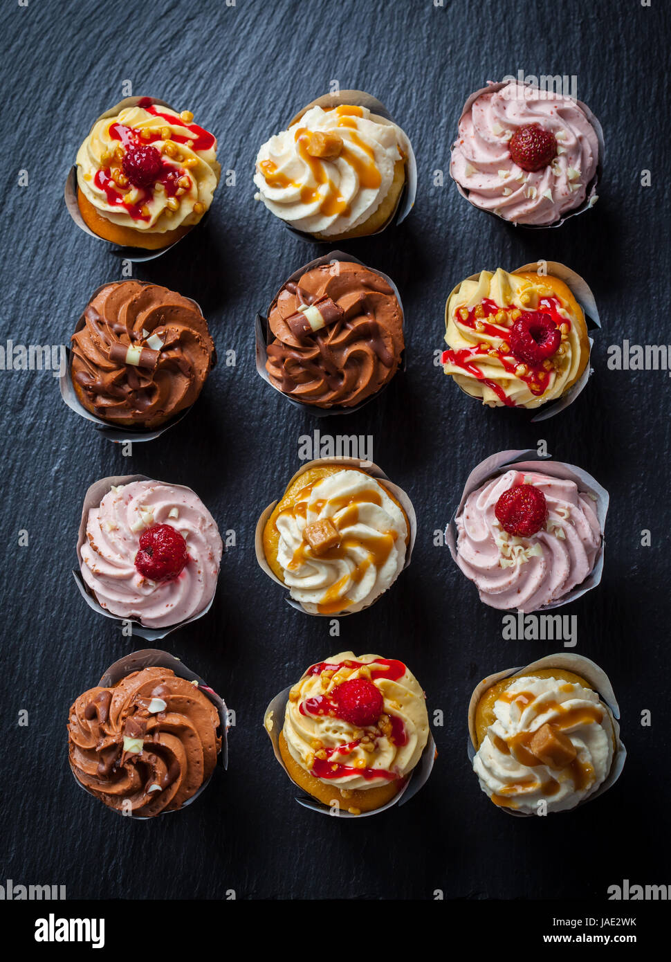 Variation of different cupcakes on black background Stock Photo - Alamy