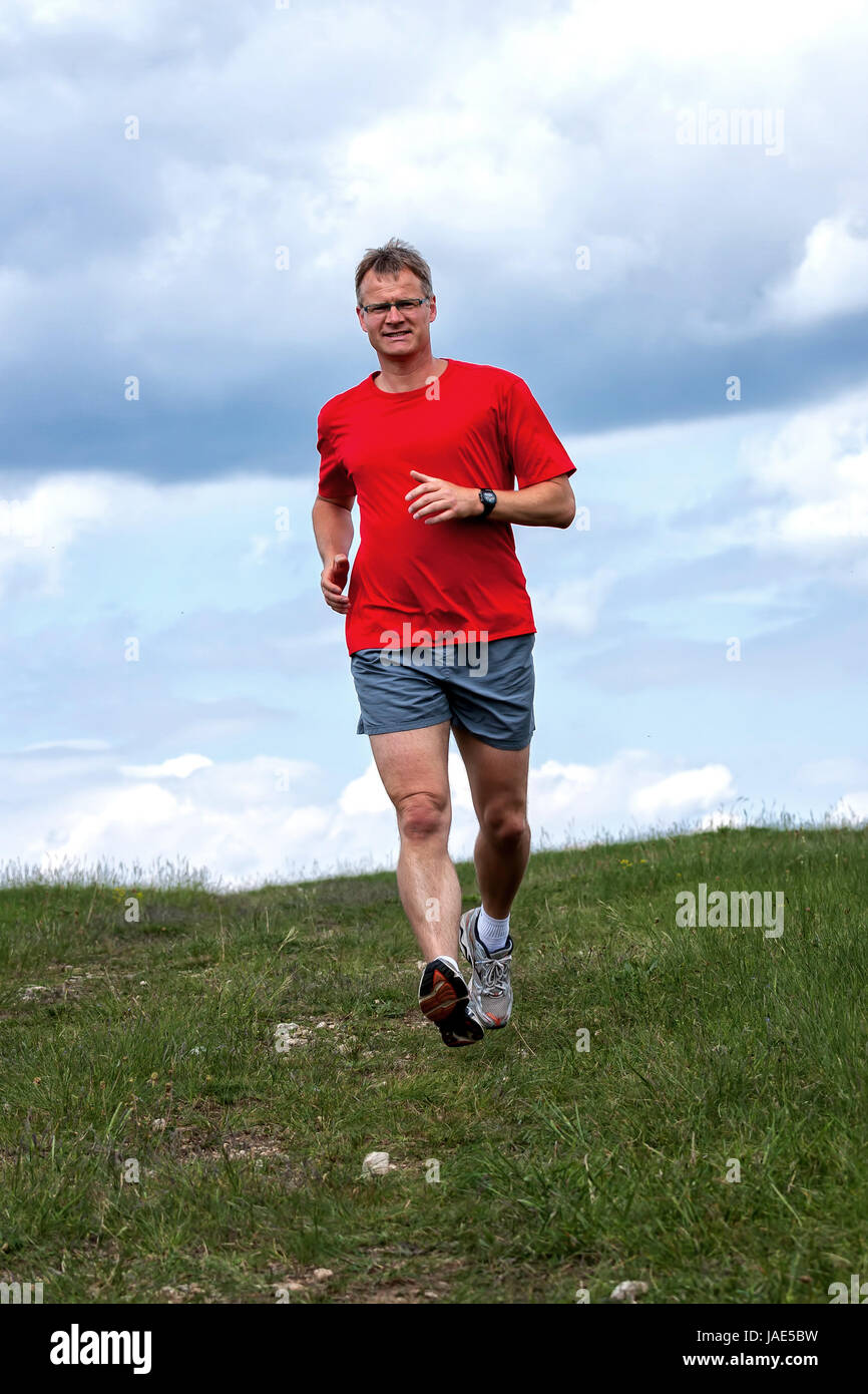 Young man running on a green field Stock Photo - Alamy