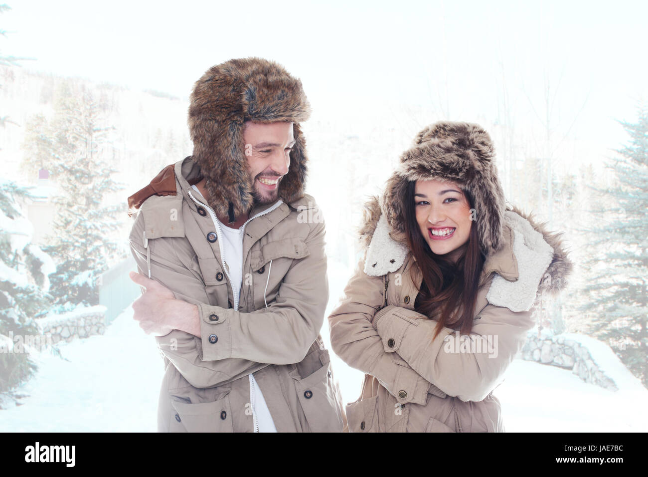 Loving couple cuddling outdoors in a snow landscape wearing heavy ...