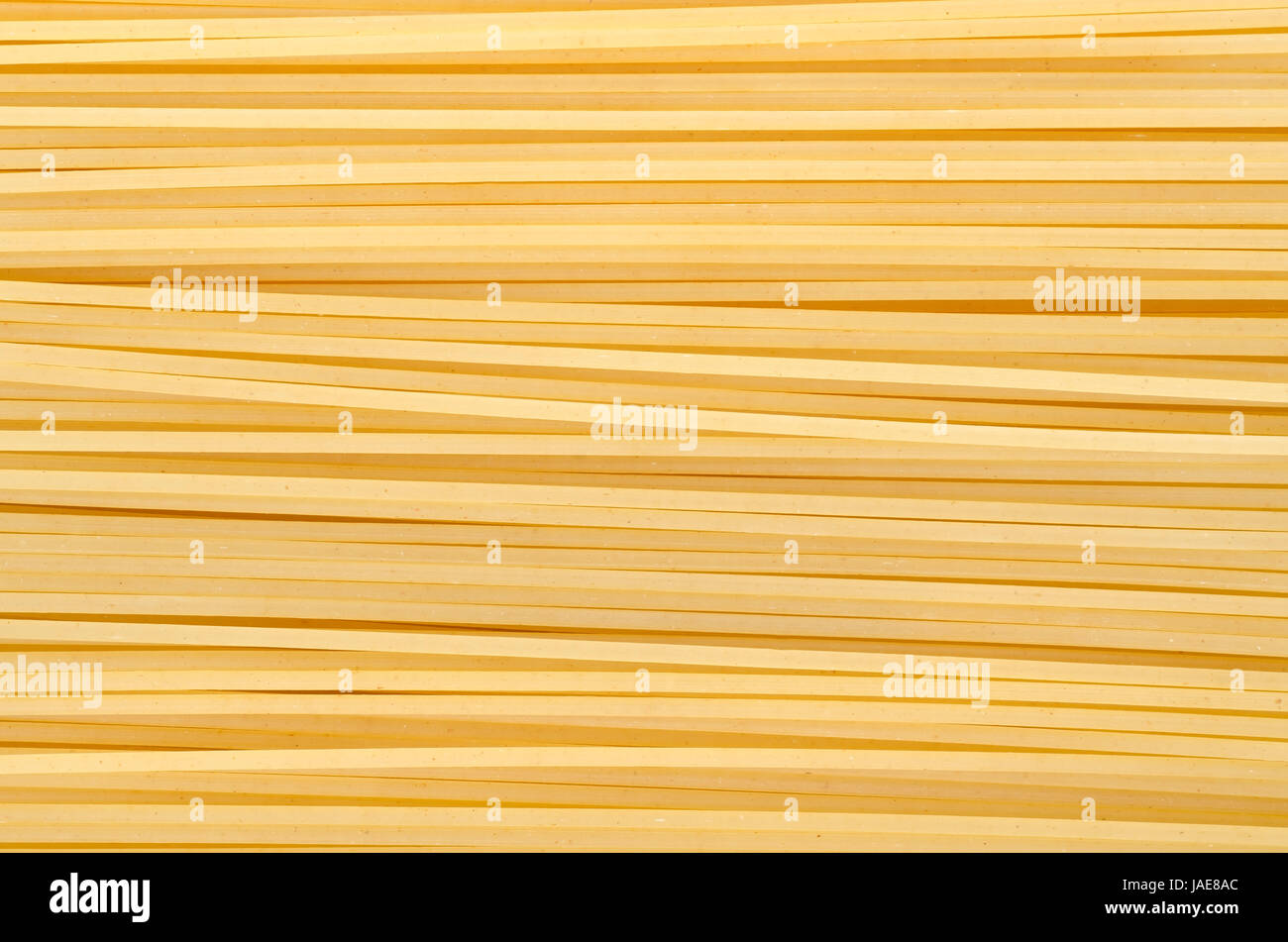 Photo of the yellow raw pasta background Stock Photo - Alamy
