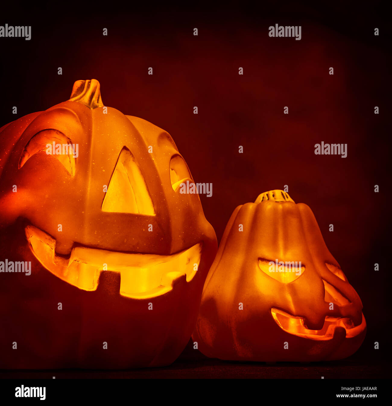 Scary carved glowing gourd on dark red background, creepy festive ...