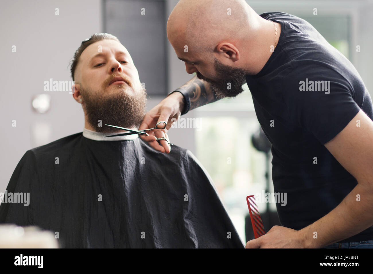 Professional barber in a barbershop doing a haircut Stock Photo - Alamy