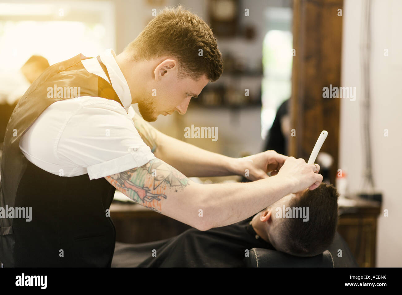Professional barber in a barbershop doing a haircut Stock Photo - Alamy