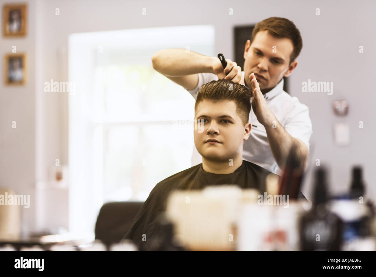 Professional barber in a barbershop doing a haircut Stock Photo - Alamy