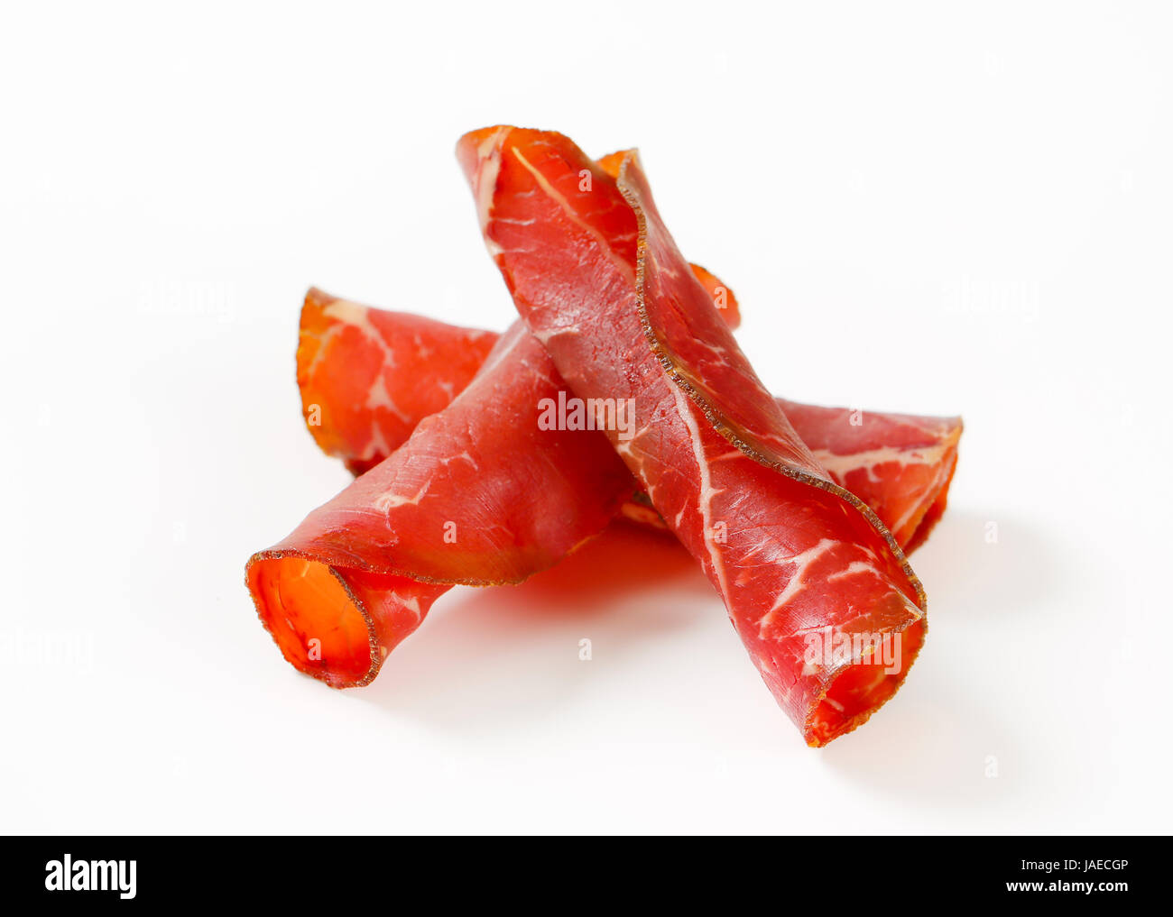 Slices of smoked marinated beef - rolled up Stock Photo - Alamy