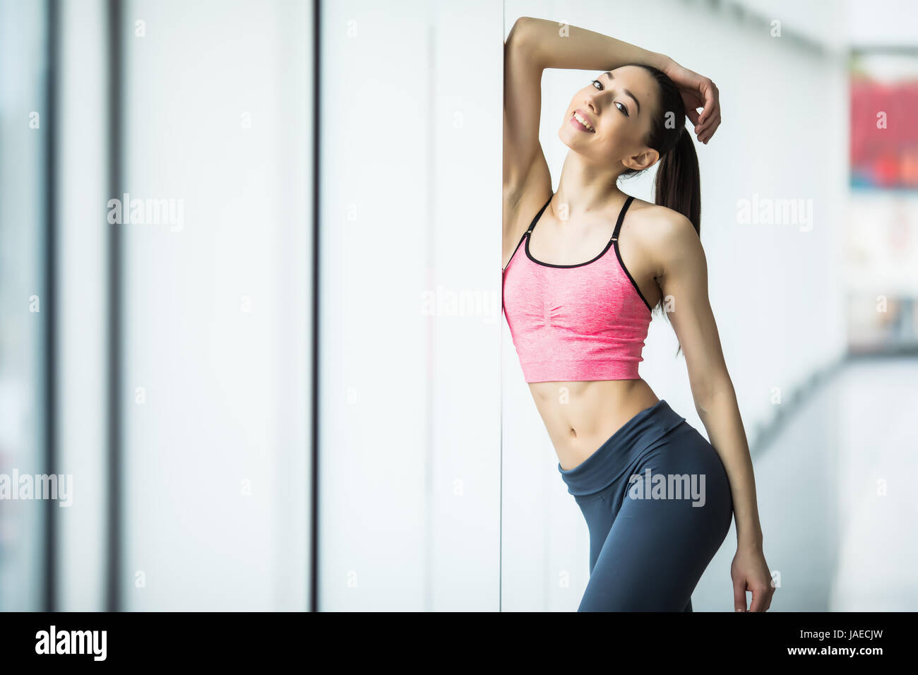 Young woman resting after workout at gym. Fitness female taking break ...