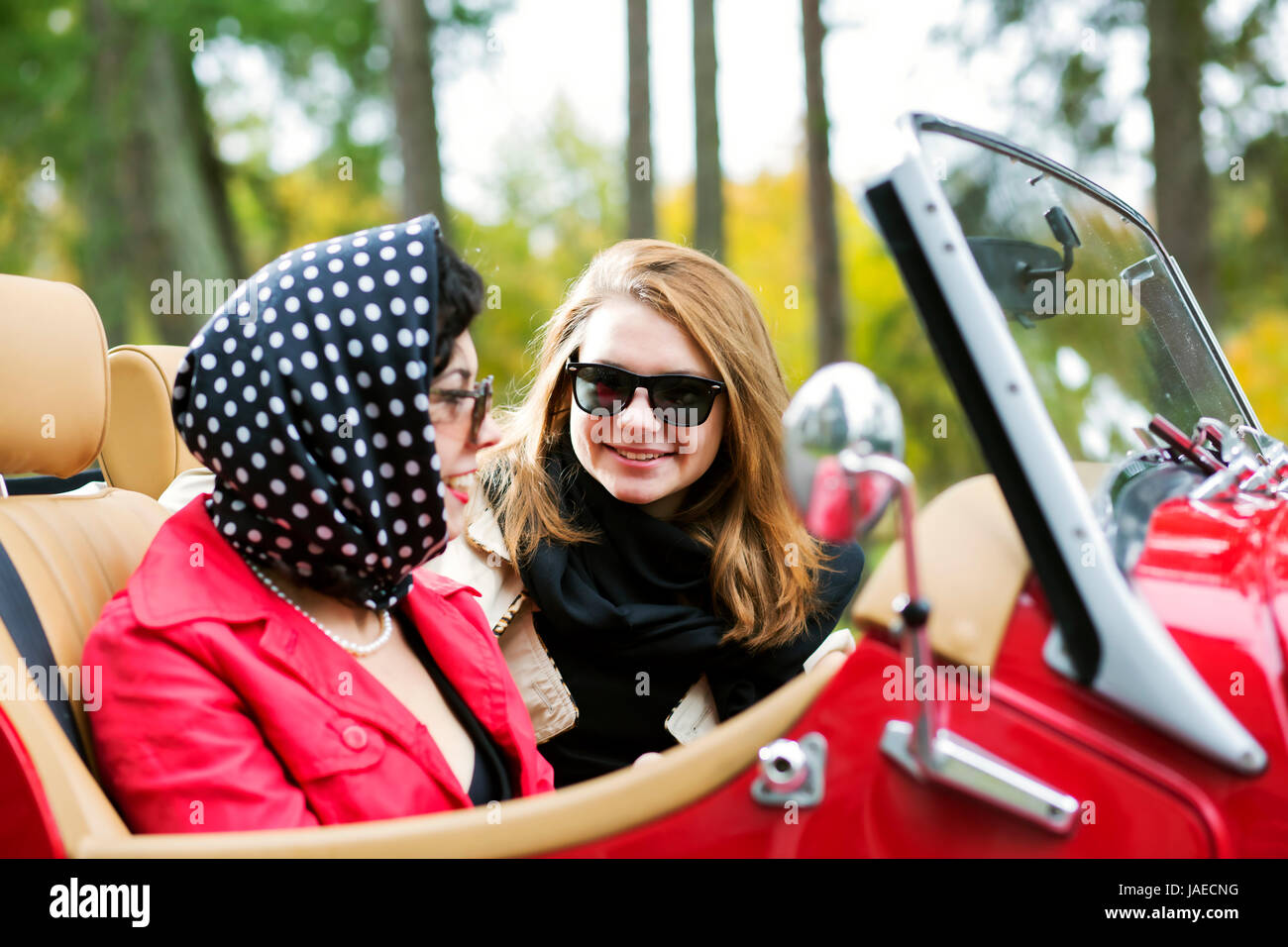 Pretty women at retro car take interesting dialog Stock Photo - Alamy