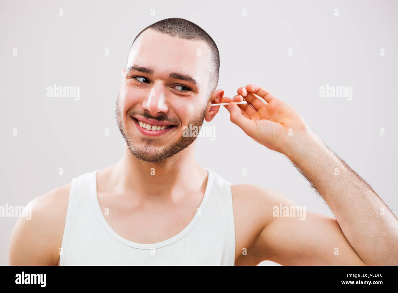 Portrait of young man who is cleaning his ears Stock Photo - Alamy