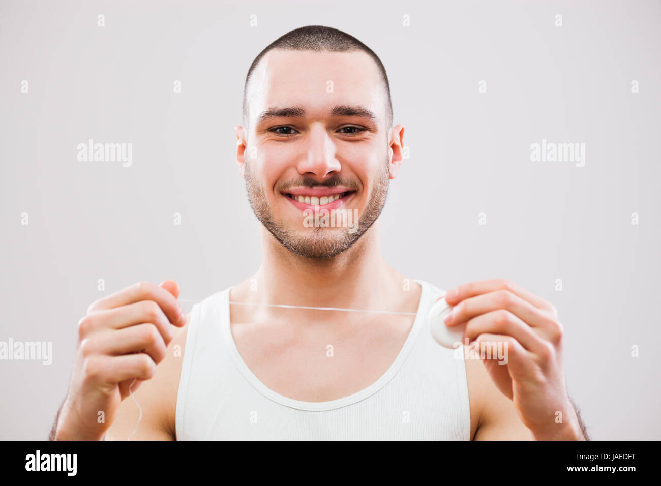 Young man is using dental floss to clean his teeth Stock Photo - Alamy