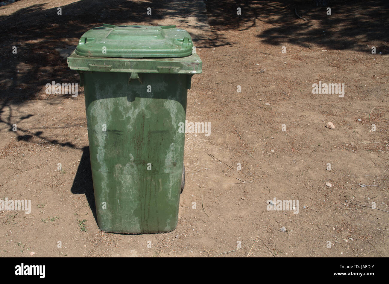 Green plastic dumpster on the ground Stock Photo - Alamy