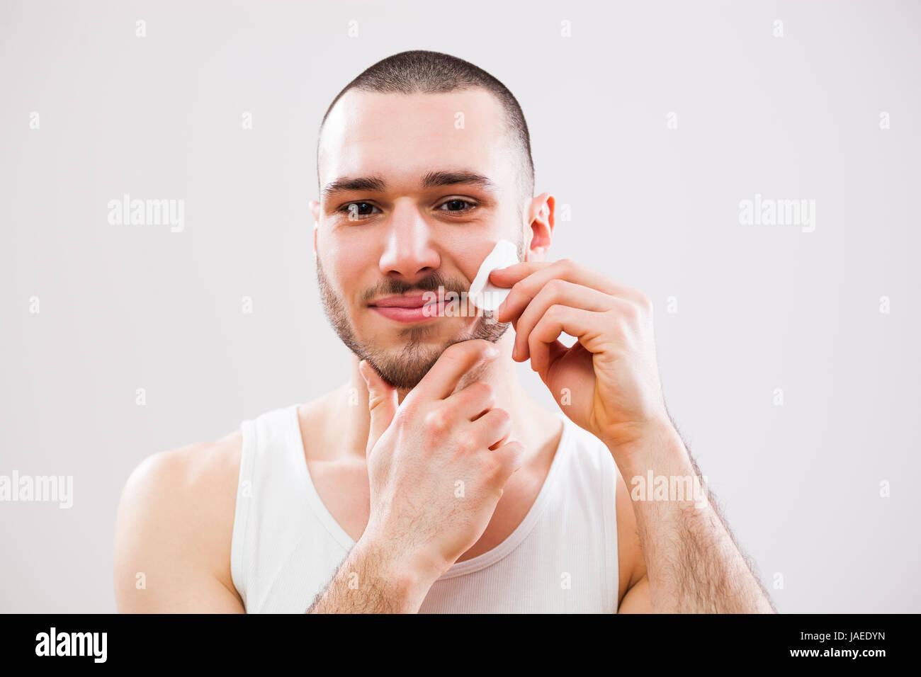 Young man is cleaning skin on his face Stock Photo - Alamy