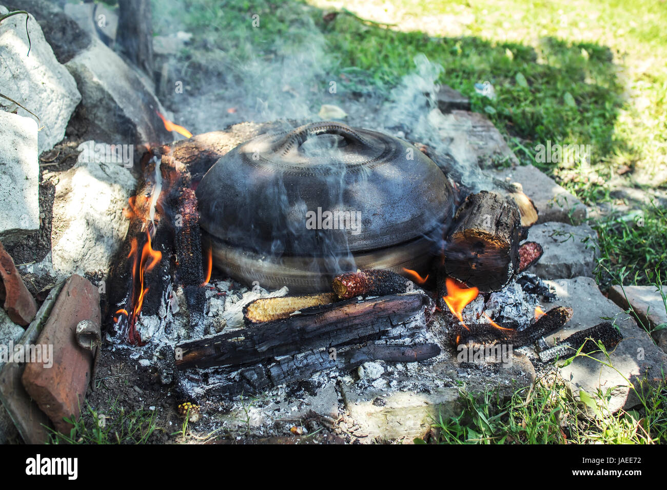 Cooking in the clay pot on fire, outdoor Stock Photo - Alamy