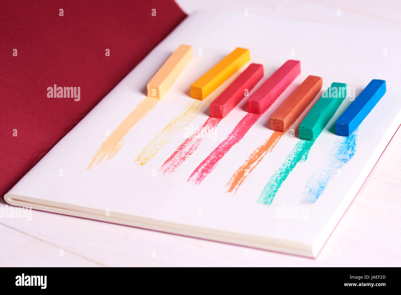 Sketch pad covered with colorful chalks Stock Photo - Alamy
