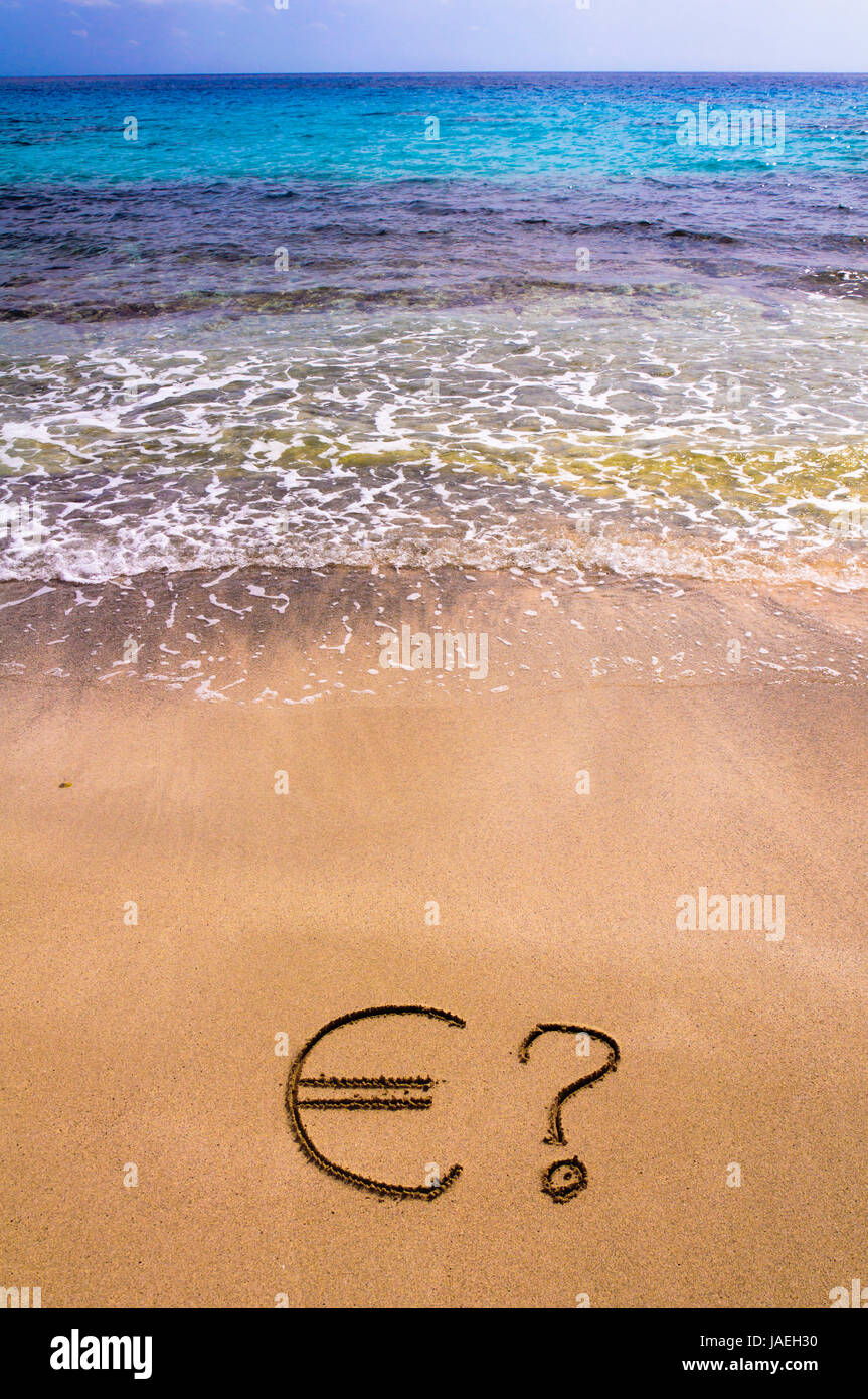 Euro sign and question mark in the sand, with blue sea water in ...