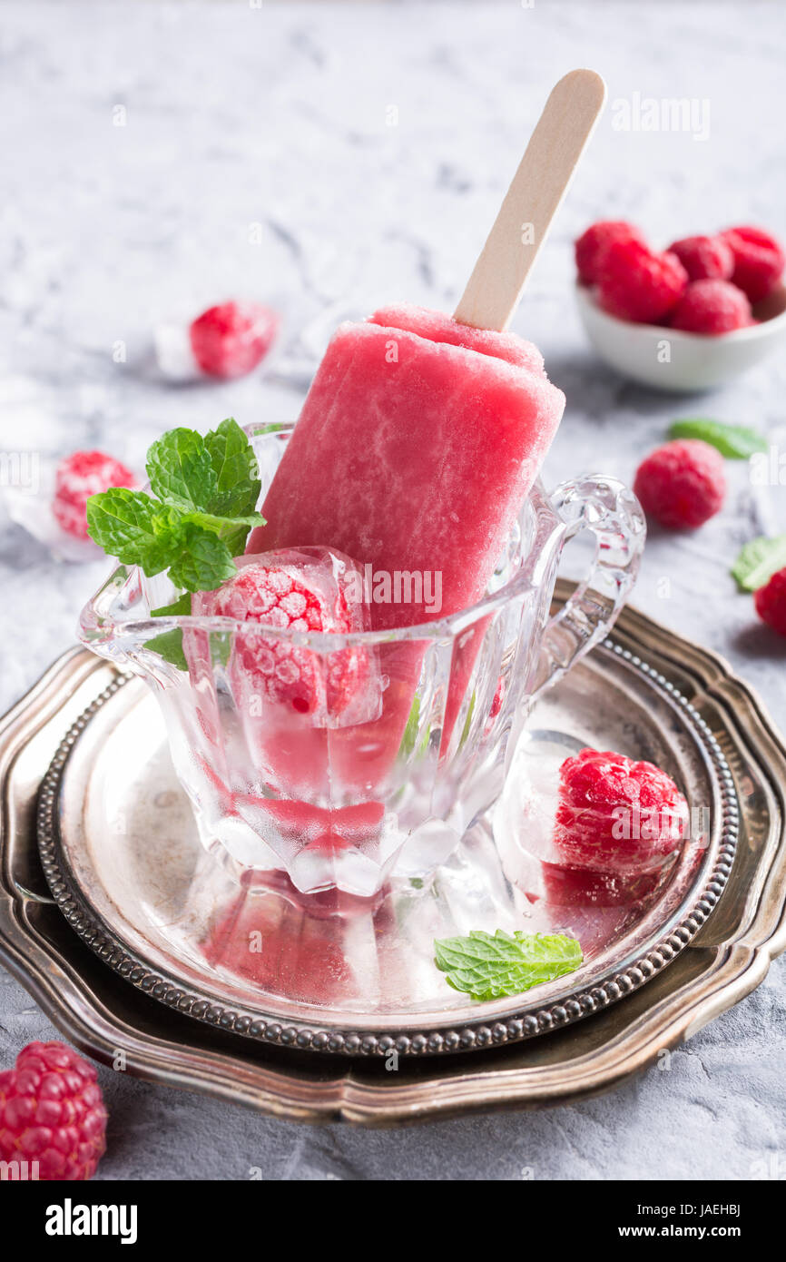 Homemade raspberry popsicles in glass with ice, raspberries and mint ...