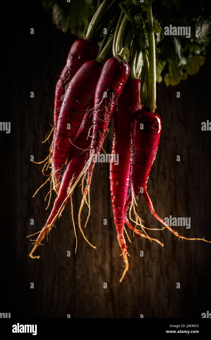 Freshly ripped bunch of long radish on dark background Stock Photo - Alamy