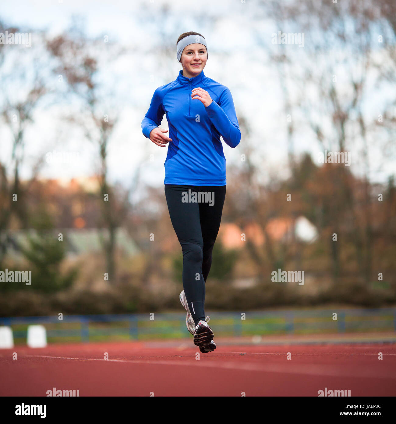 Young woman running at a track and field stadium Stock Photo - Alamy