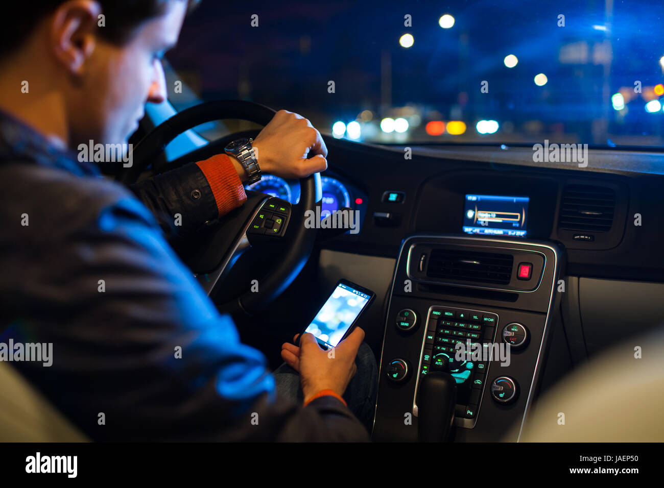 Driving a car at night -man driving his modern car at night in a city ...