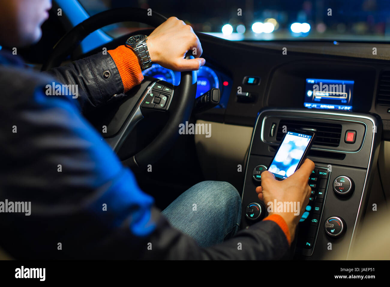 Driving a car at night -man driving his modern car at night in a city ...