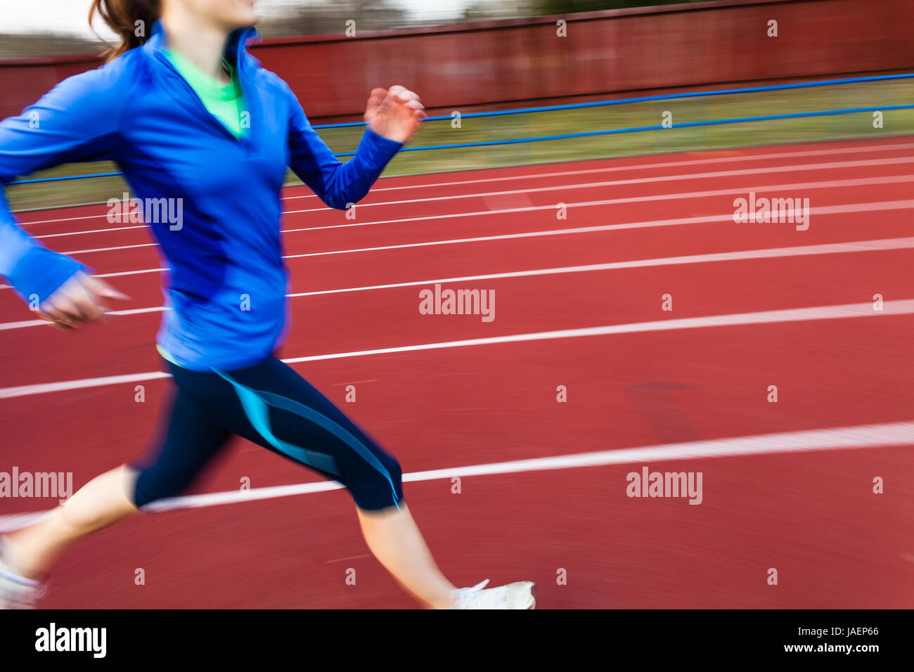 Young woman running at a track and field stadium Stock Photo - Alamy